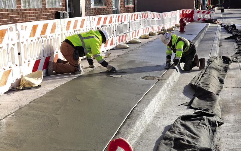 Crews correcting sloped portions of sidewalk boulevard on North River ...